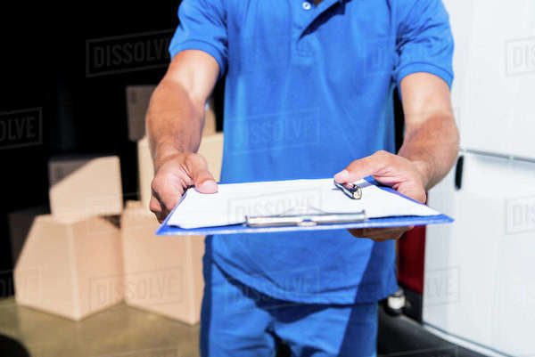 Cropped shot of delivery man with clipboard - Royalty-free Stock Photo | Dissolve