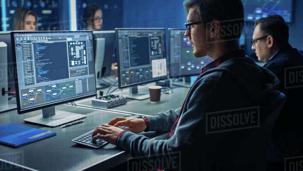 Smart Male IT Programer Working on Desktop Green Mock-up Screen Computer in Data Center System ...