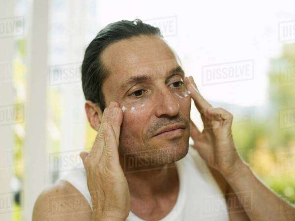 Man applying moisturizer to face - Royalty-free Stock Photo | Dissolve