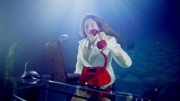 Cheerful underwater businesswoman makes a phone call from her ...