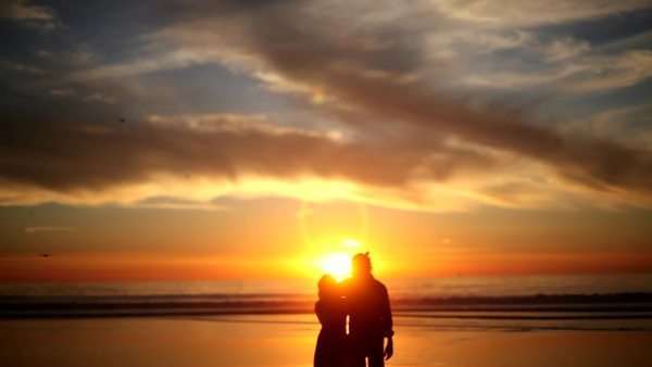 Silhouette of couple kissing and hugging in front of beautiful sunset ...