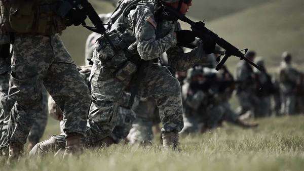 Static shot of a firing line alternating shooters to fire in kneeling ...