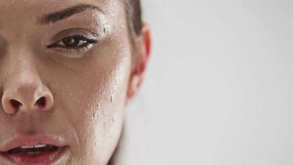 Close-up of half of face of athletic Caucasian woman sweating and ...