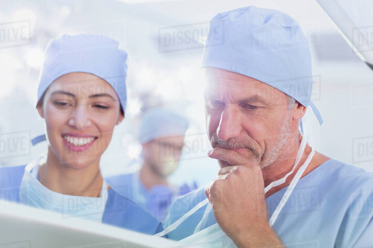 Surgeons reviewing paperwork in operating room - Royalty-free Stock ...