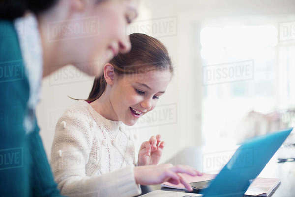 Smiling girl using laptop - Royalty-free Stock Photo | Dissolve