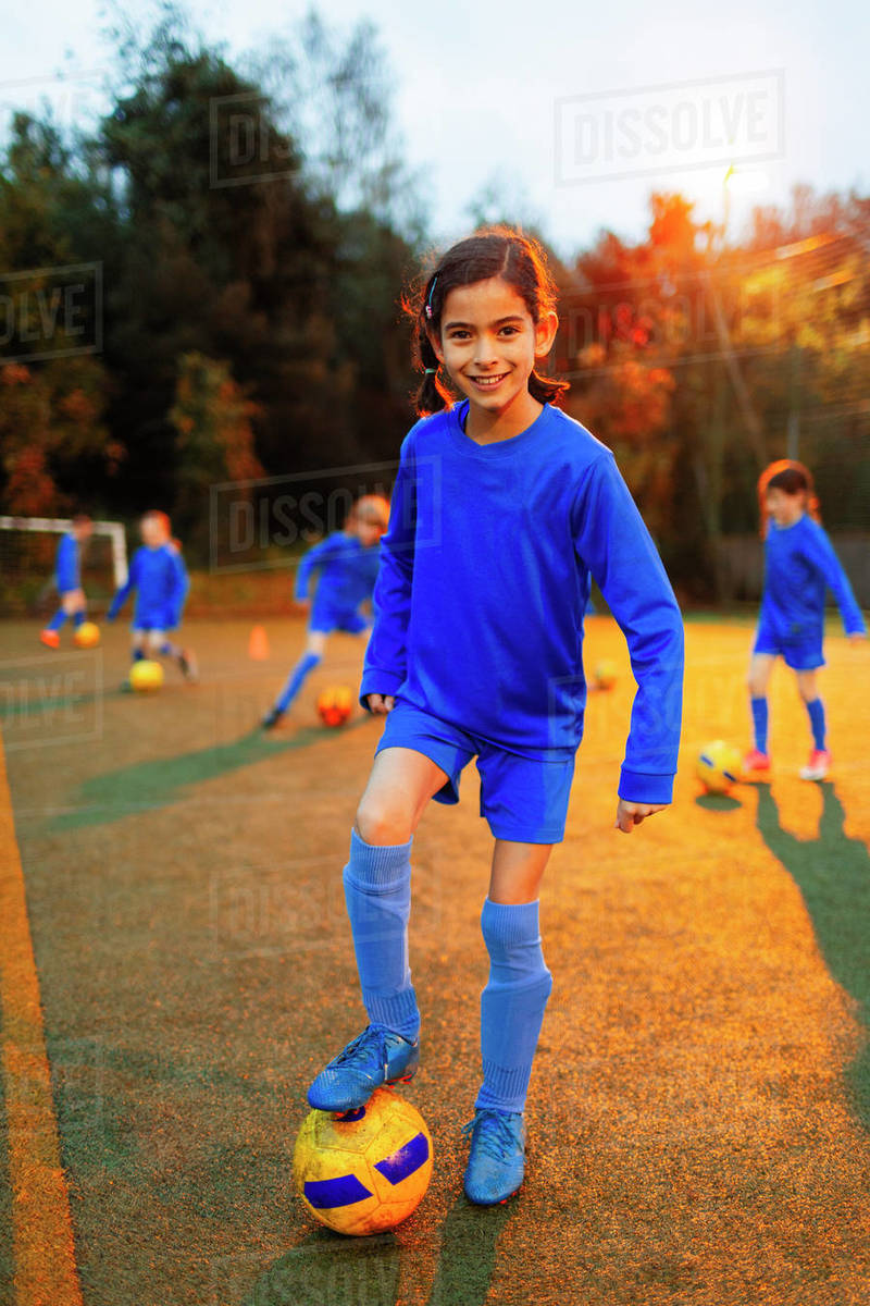 Portrait confident girl practicing soccer on field - Royalty-free Stock ...