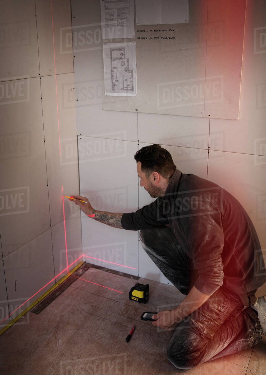 Construction worker using laser measuring tool - Royalty-free Stock ...