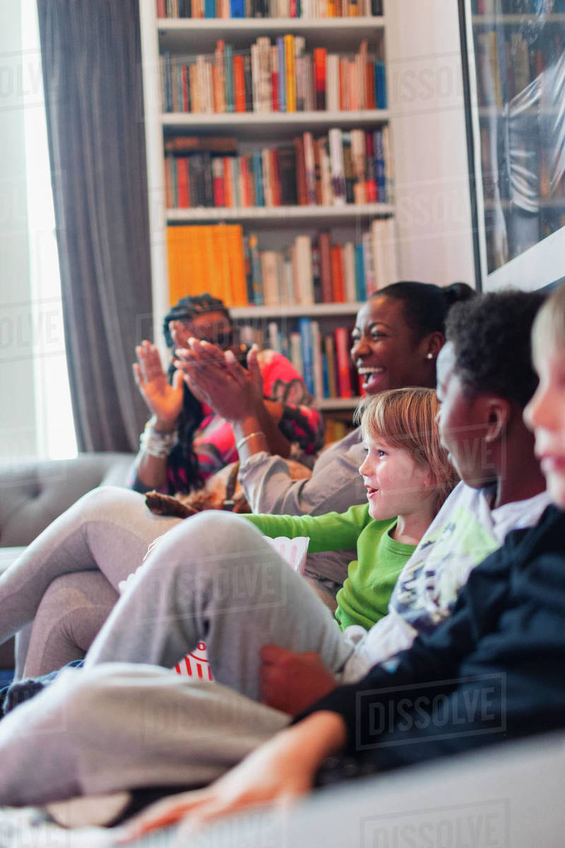 Happy family clapping on living room sofa - Royalty-free Stock Photo ...