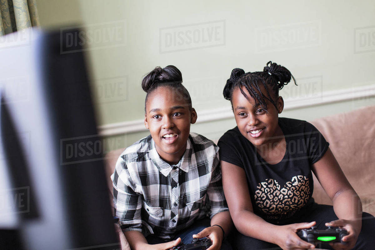 Tween girl friends playing video game in living room - Stock Photo ...
