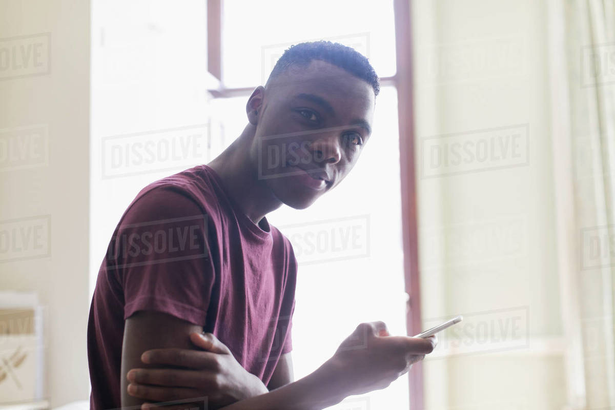 Portrait teenage boy texting with smart phone - Stock Photo - Dissolve