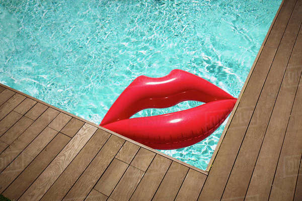 Inflatable lips floating in sunny summer swimming pool - Stock Photo ...