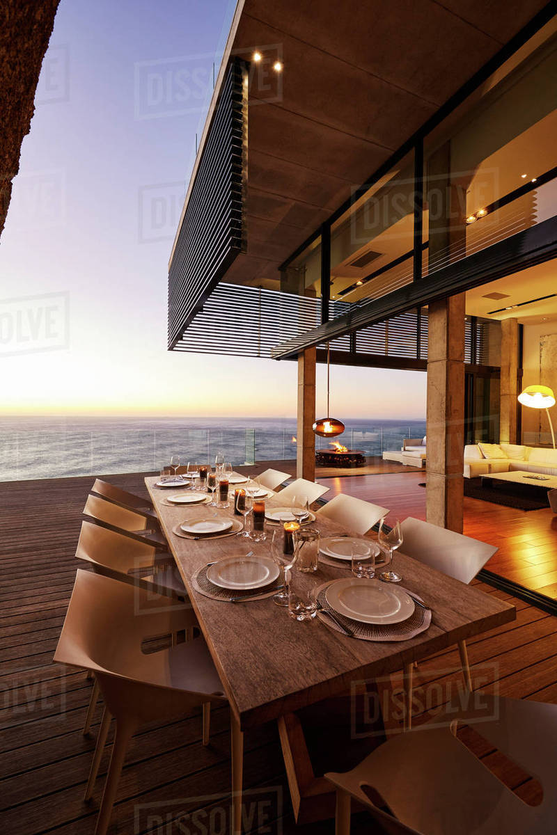 Luxury modern dining table with sunset ocean view - Stock Photo - Dissolve