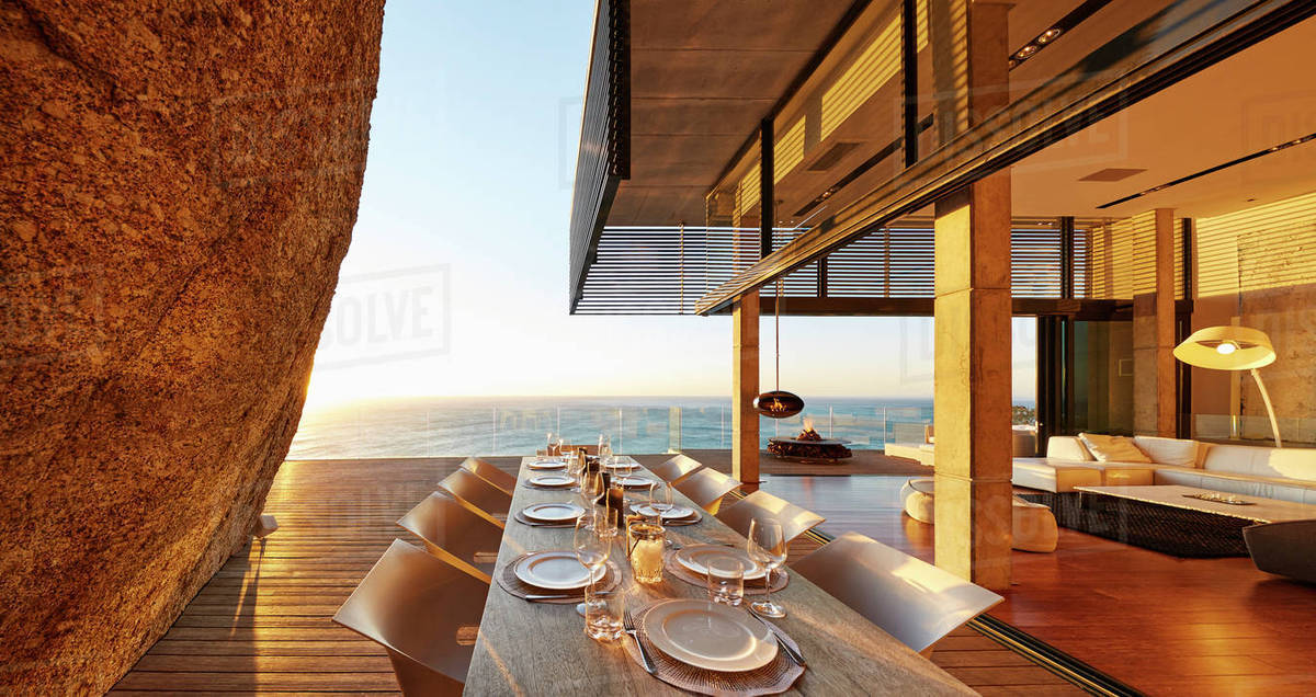 Modern luxury patio dining table with sunset ocean view - Royalty-free ...