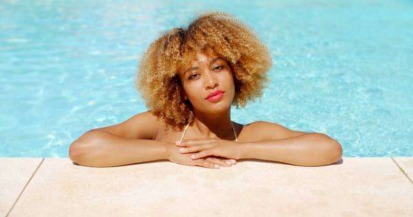 Girl with afro haircut relaxing in outdoor swimming pool. slow motion ...
