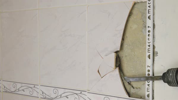 Demolition hammer breaking a tile wall - Stock Video Footage - Dissolve