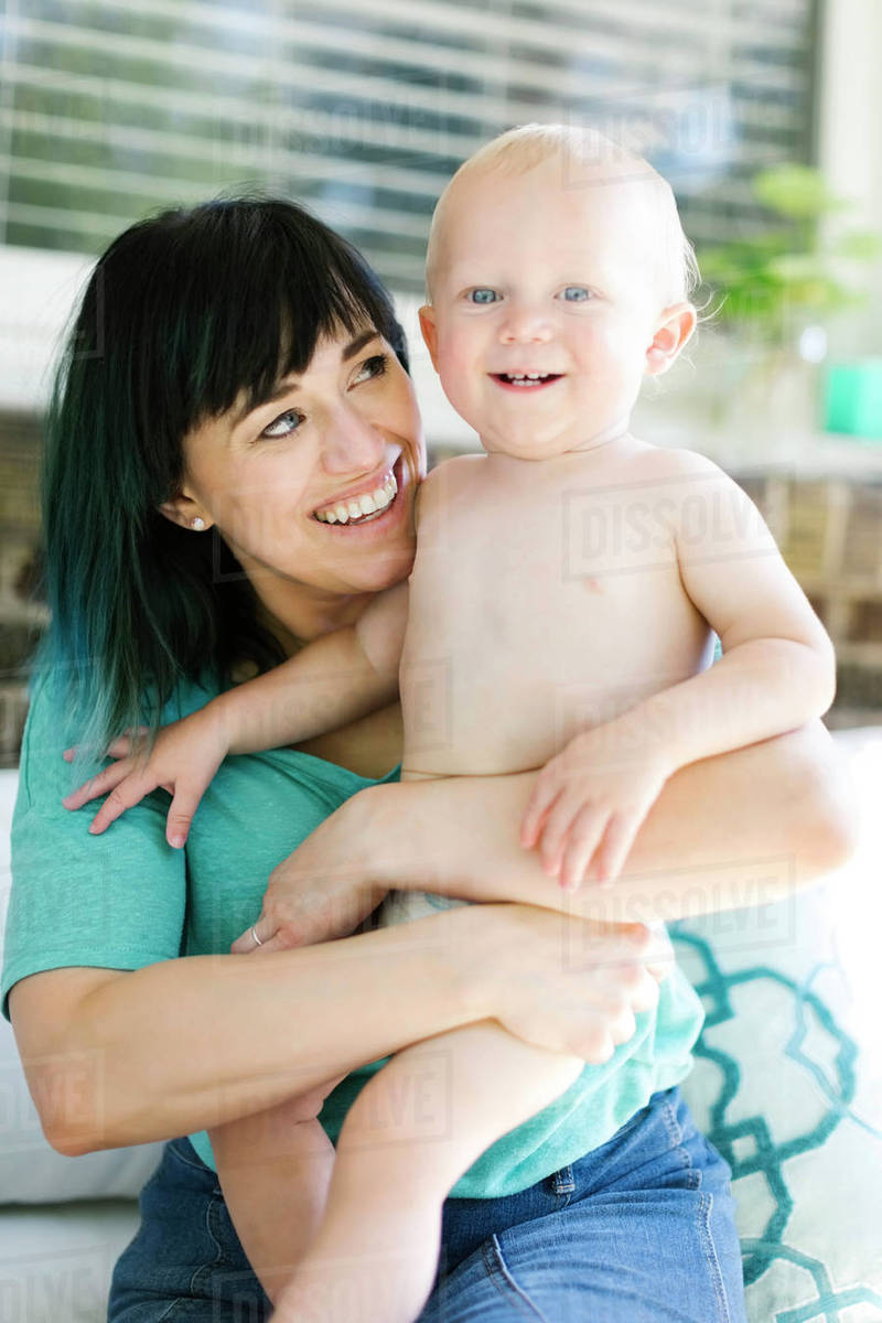 Mother carrying baby boy on porch - Stock Photo - Dissolve