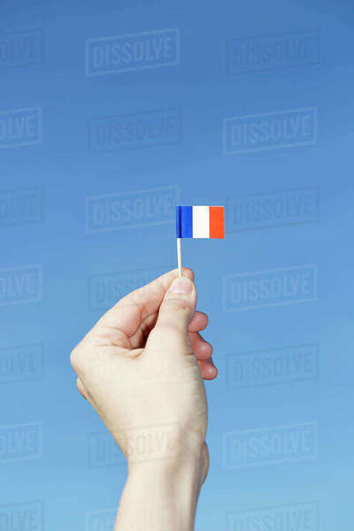 Woman holding French flag in hand - Royalty-free Stock Photo | Dissolve