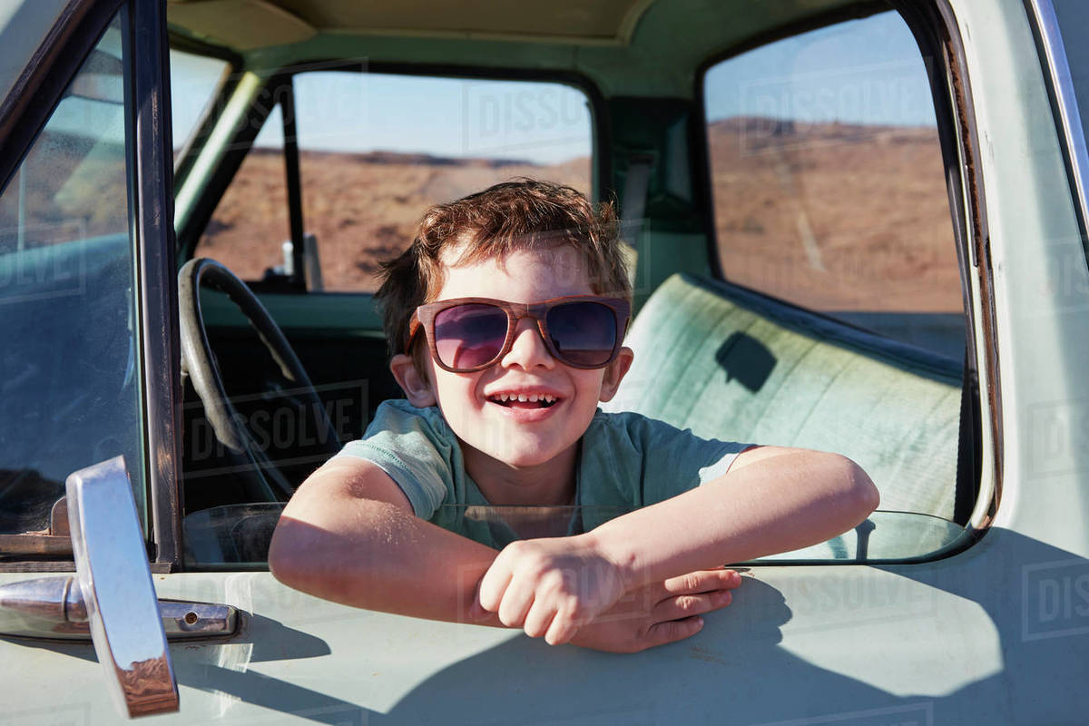 USA, Arizona, Portrait of smiling boy sitting in pick-up truck ...
