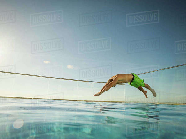 Man jumping into swimming pool - Stock Photo - Dissolve