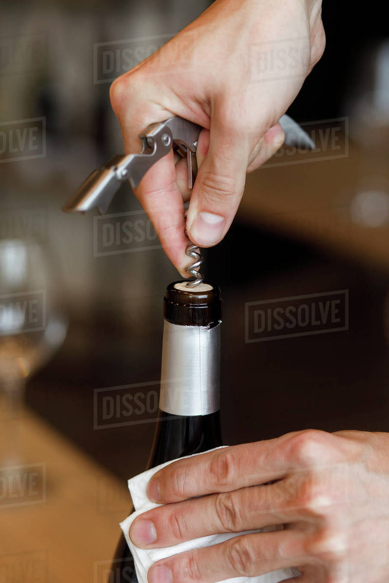 Hands of man opening bottle of wine - Royalty-free Stock Photo | Dissolve