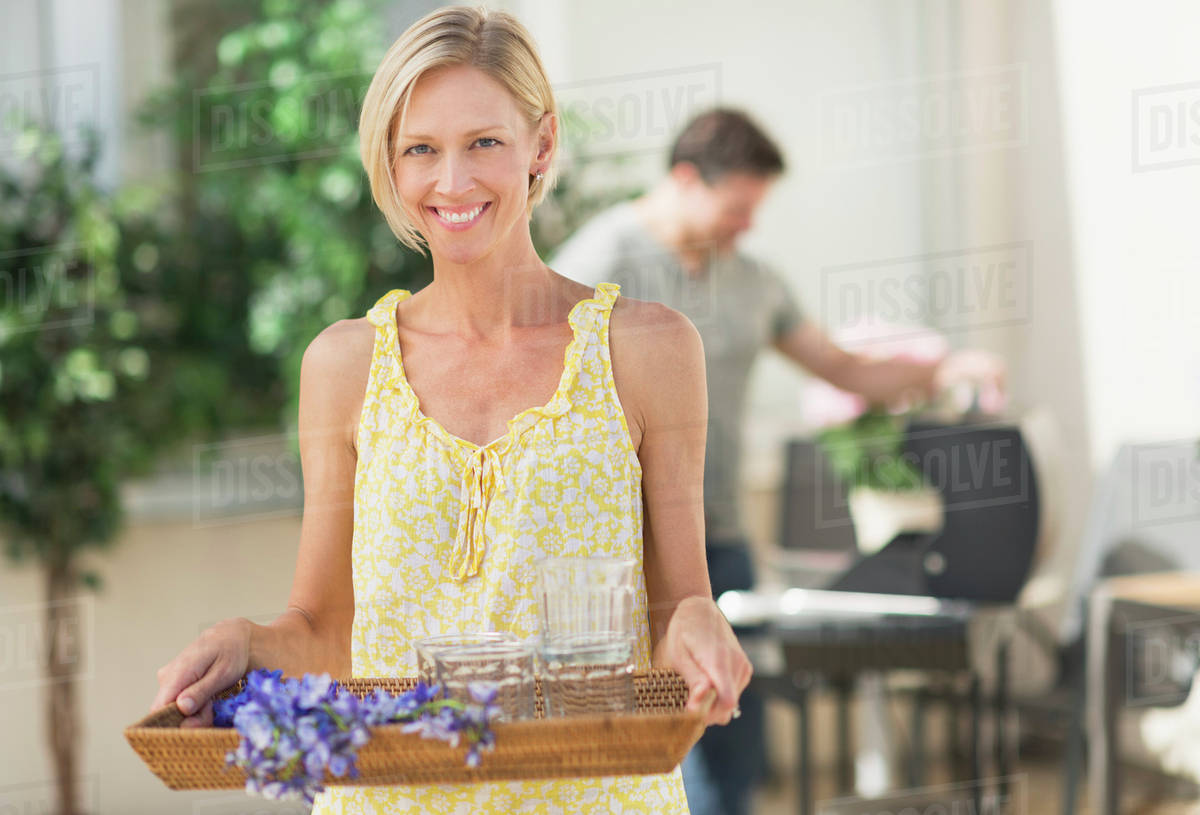 Woman carrying tray with crockery and flowers - Royalty-free Stock ...