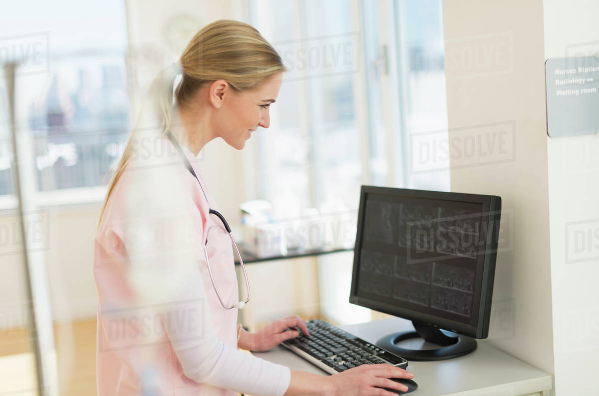 Female nurse working on computer - Stock Photo - Dissolve