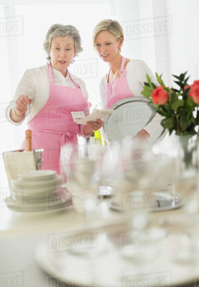 Two mature women preparing catering - Stock Photo - Dissolve