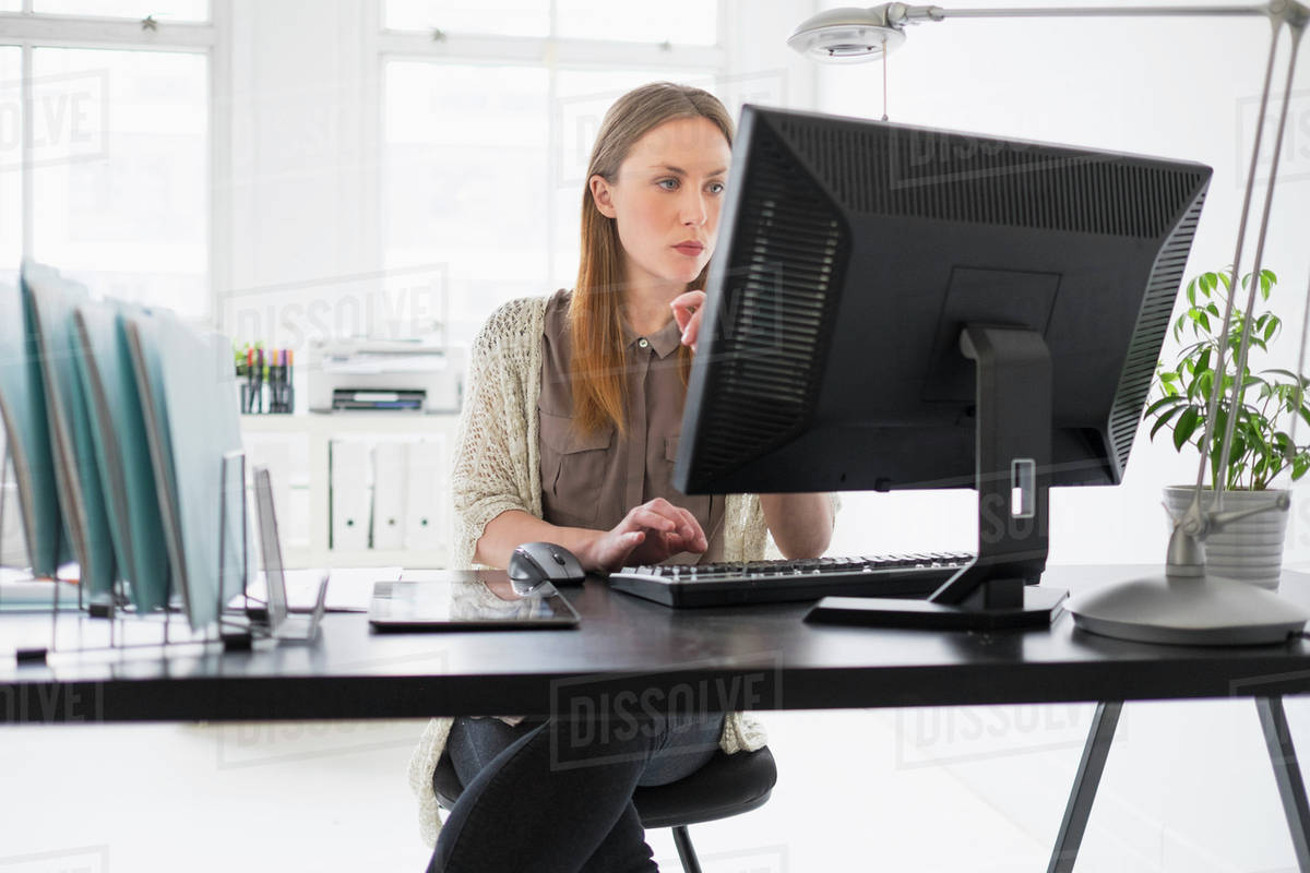 Portrait of young woman working on computer in office - Royalty-free ...