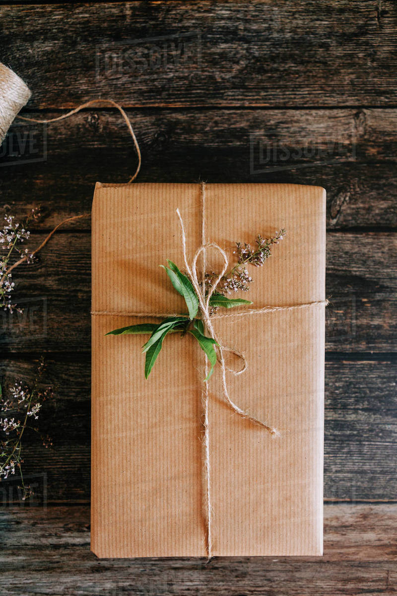 Present wrapped in brown paper with string and flowers - Royalty-free ...