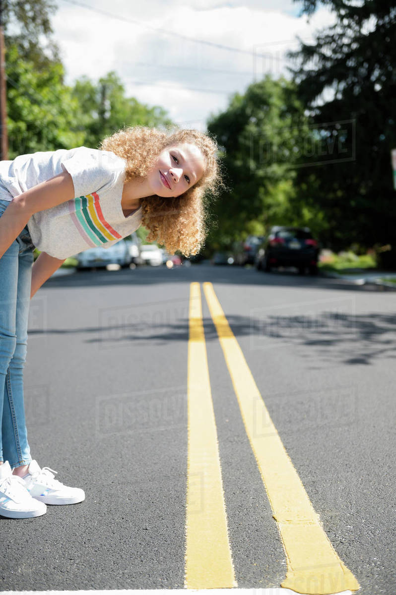 Girl leaning over on road - Royalty-free Stock Photo | Dissolve