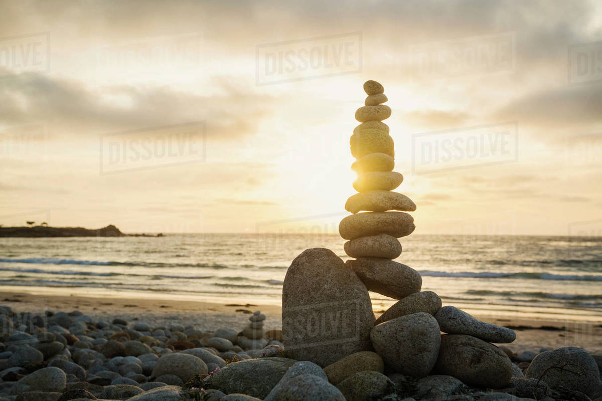Stacked stones on beach at sunset - Royalty-free Stock Photo | Dissolve