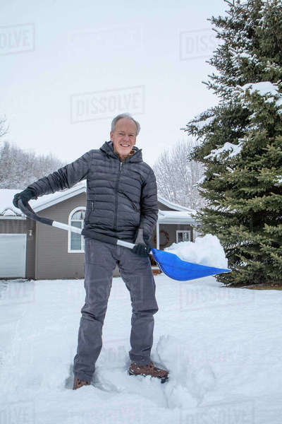 Senior man shoveling snow - Stock Photo - Dissolve