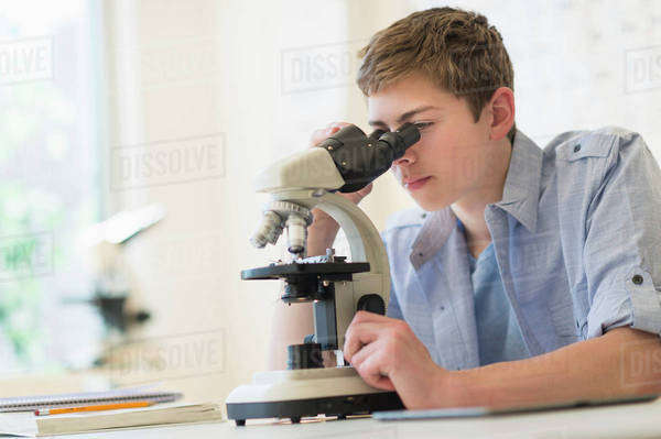 Teenage boy (16-17) looking through microscope - Royalty-free Stock ...
