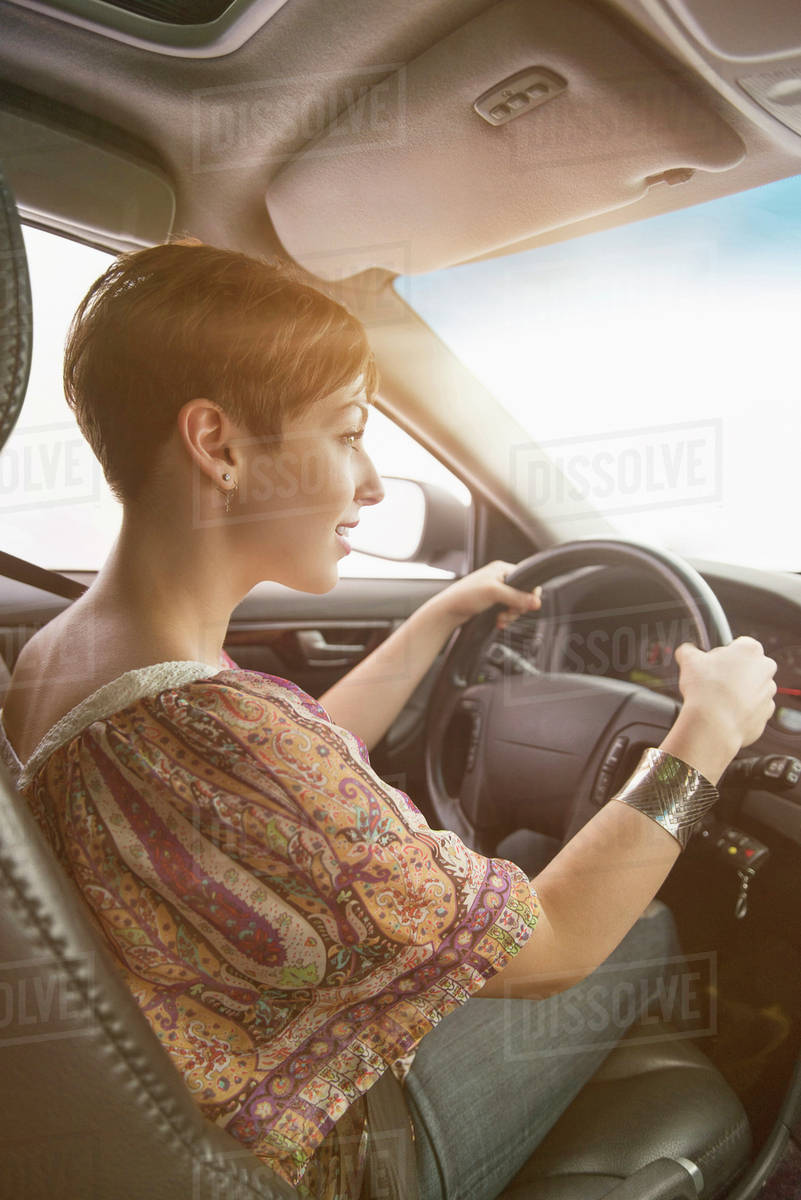 Side view of woman driving car - Royalty-free Stock Photo | Dissolve