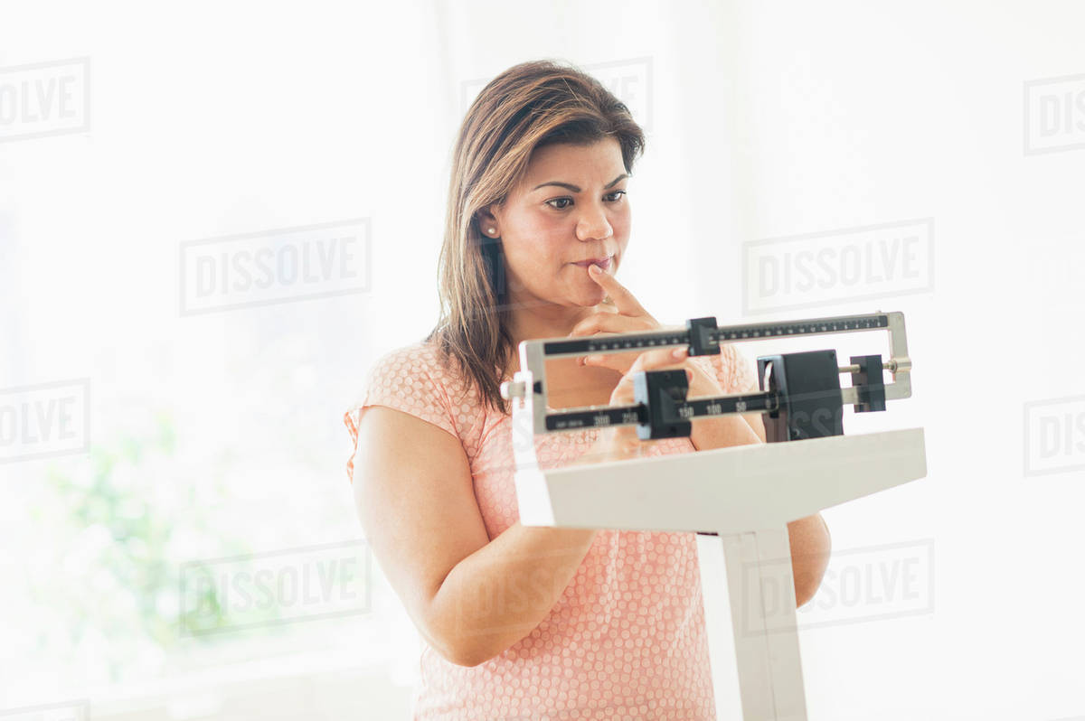 Woman standing on scale - Stock Photo - Dissolve