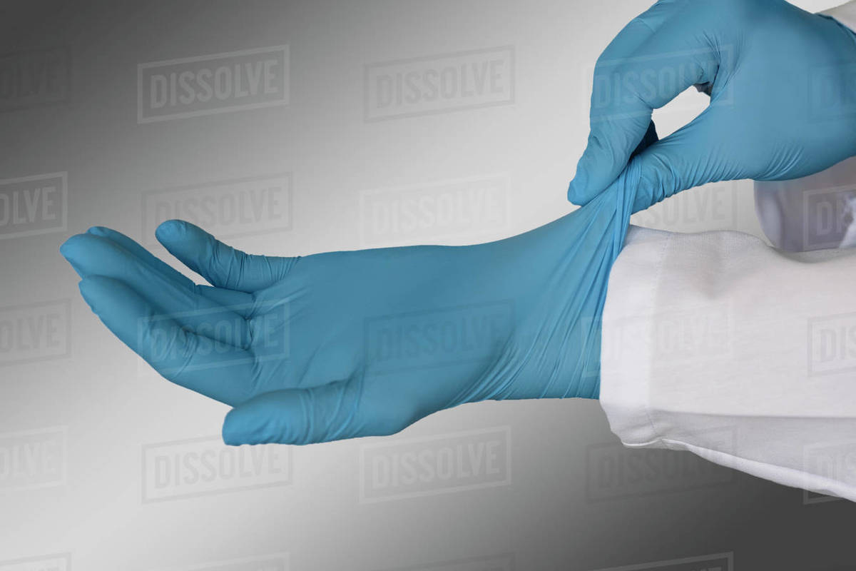 Person putting on blue surgical gloves - Royalty-free Stock Photo ...