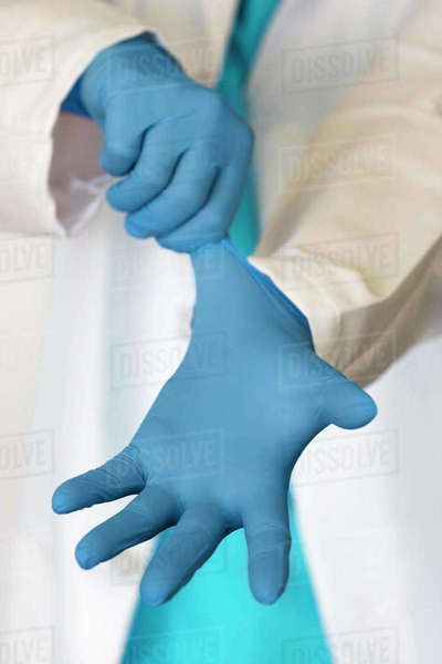 Person putting on blue surgical gloves - Royalty-free Stock Photo ...
