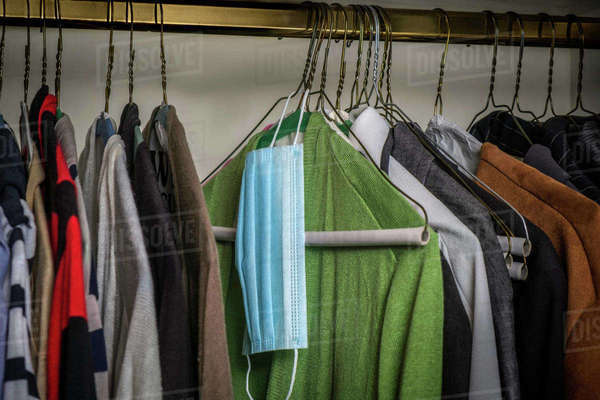 Surgical mask hanging on hanger on rack with clothes - Royalty-free ...