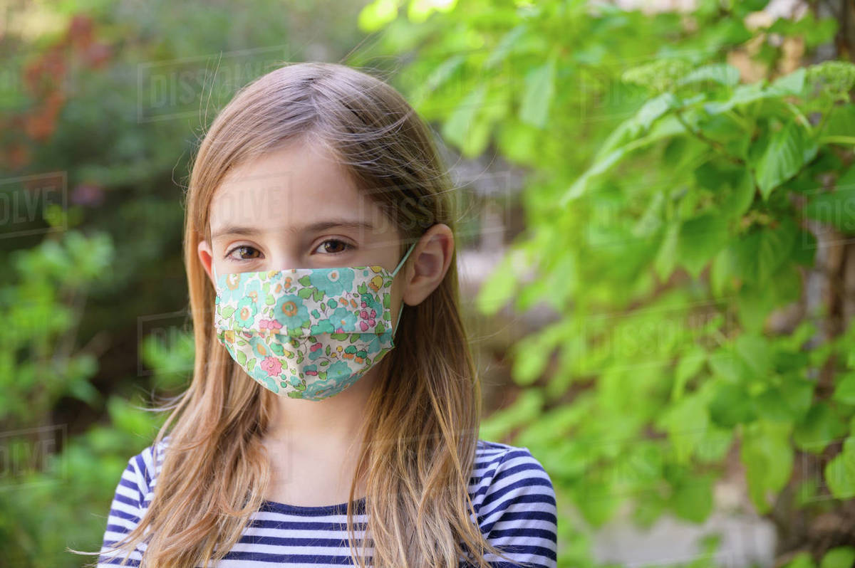 Portrait of girl (-6-7) wearing face mask - Stock Photo - Dissolve