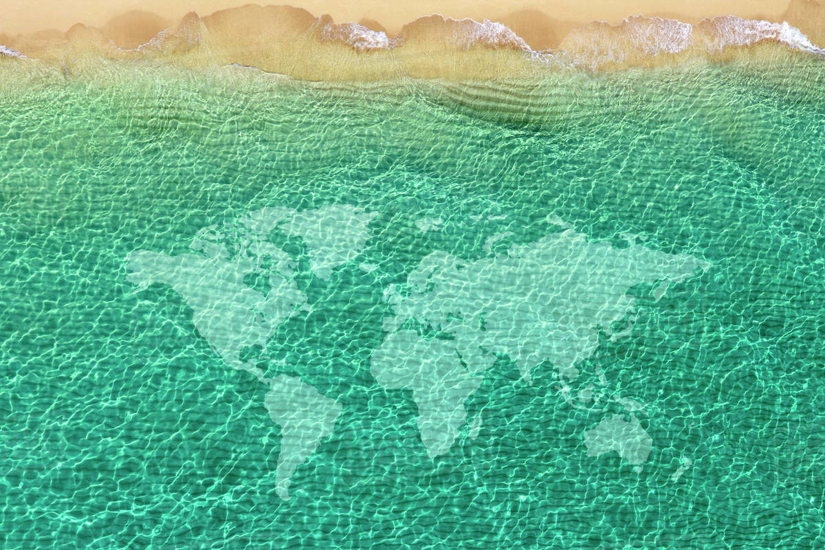 World map against beach wave - Stock Photo - Dissolve