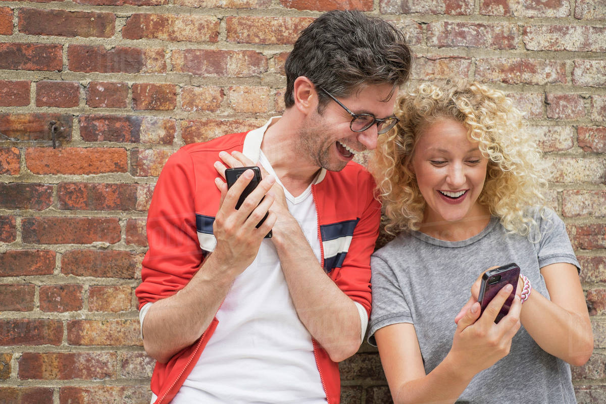 Couple sharing messages on cell phones - Royalty-free Stock Photo ...