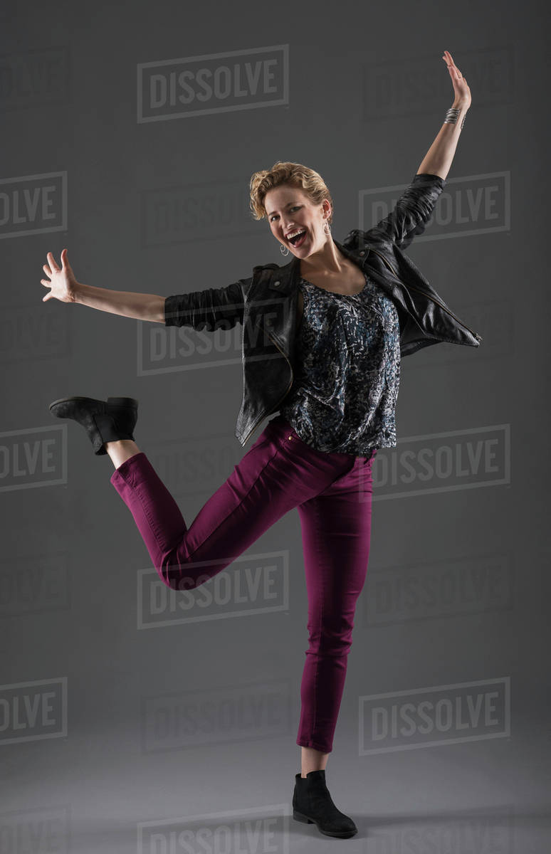 Studio shot of cheerful woman with arms raised - Royalty-free Stock ...