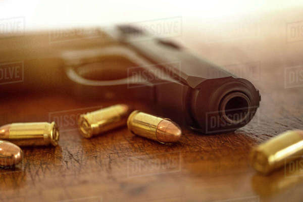 Gold bullets and pistol on wooden surface - Royalty-free Stock Photo ...
