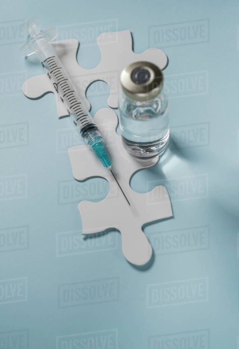 Vial of Covid-19 vaccine and syringe on jigsaw puzzles - Royalty-free ...