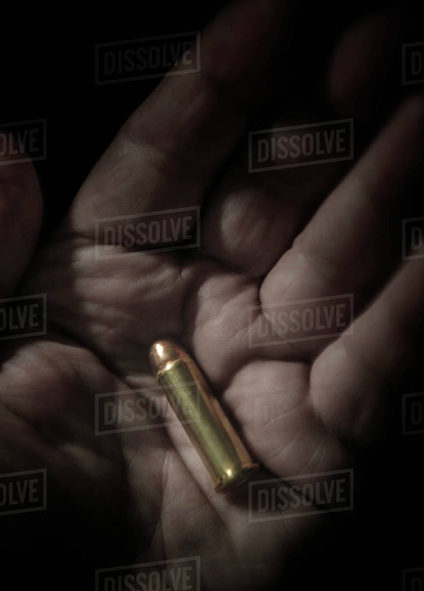 Close-up of hand holding bullet - Royalty-free Stock Photo | Dissolve