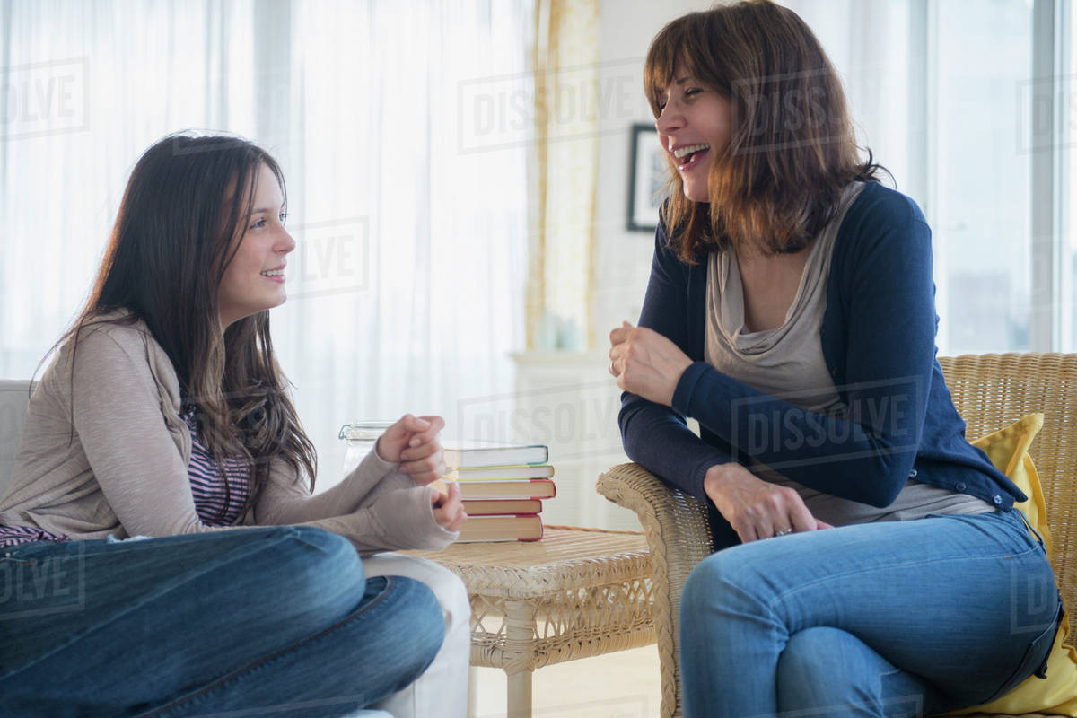 Teenage girl (14-15) talking with her mom in living room - Stock Photo ...
