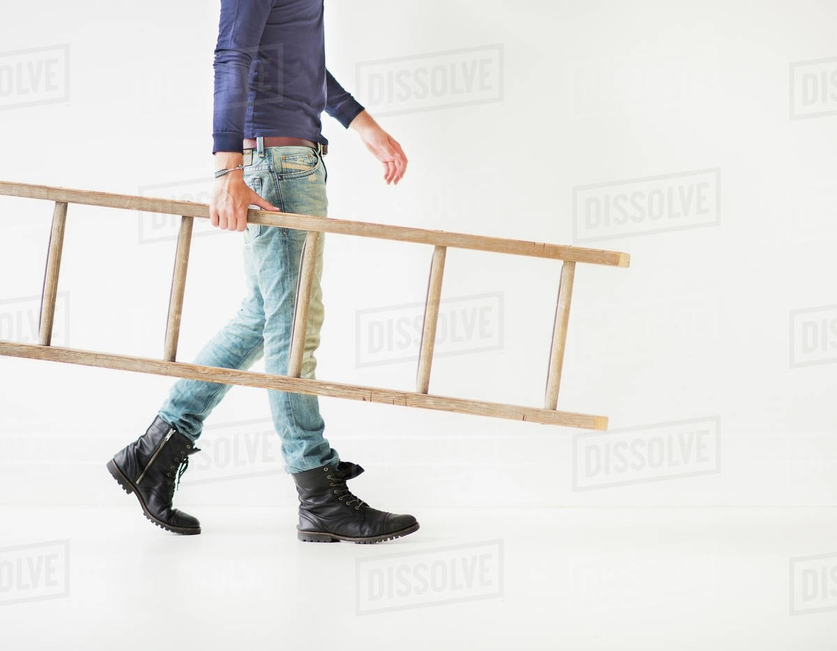 Low section of man carrying ladder - Royalty-free Stock Photo | Dissolve