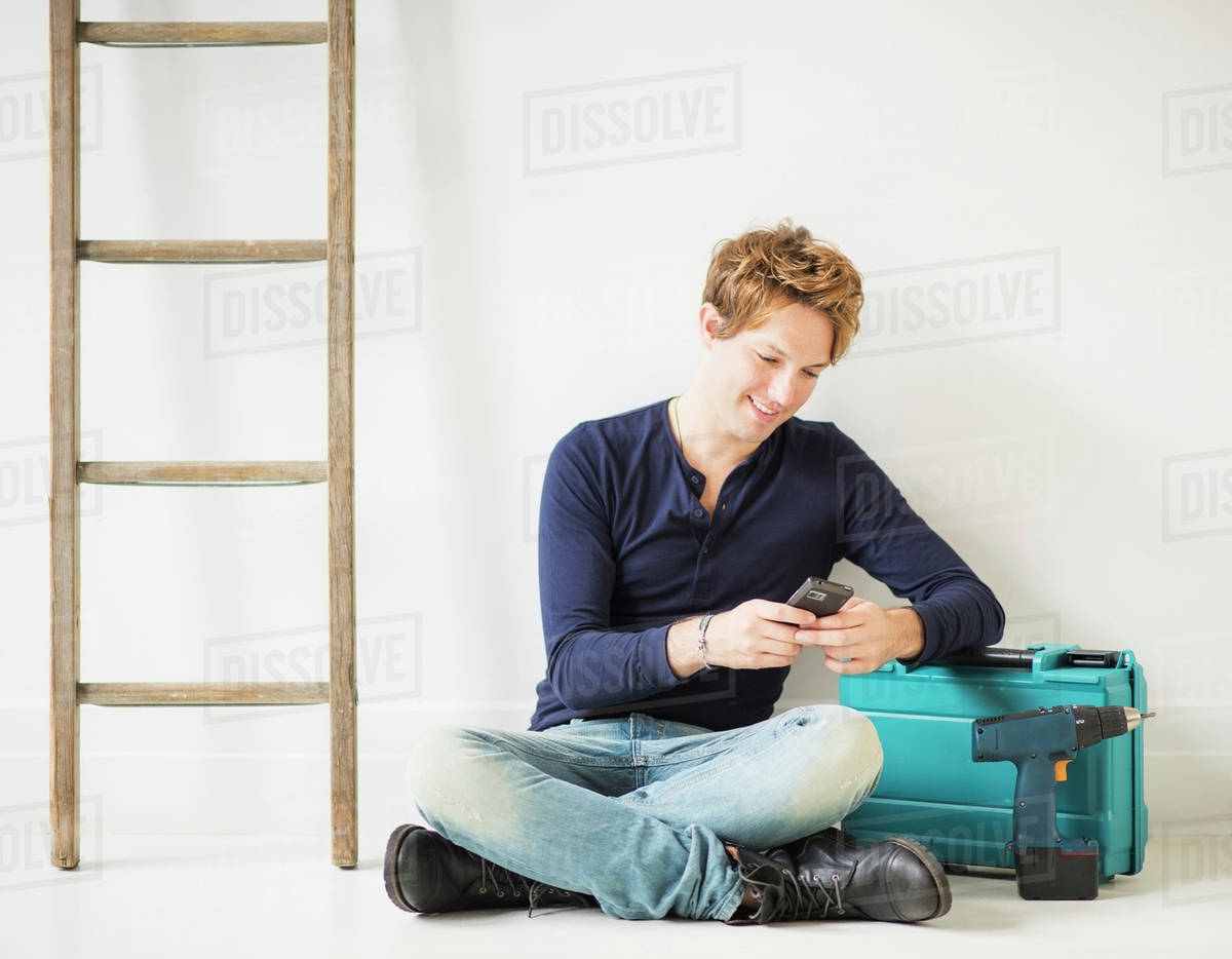 Man with toolbox using phone - Royalty-free Stock Photo | Dissolve