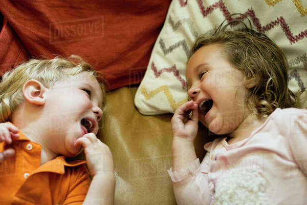 Male and female toddler friends giggling on sofa - Royalty-free Stock ...