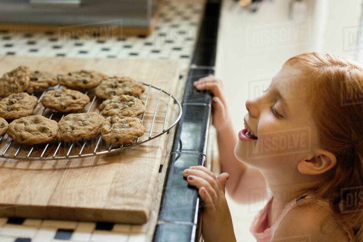 Girl peeking over kitchen counter at biscuits - Royalty-free Stock ...